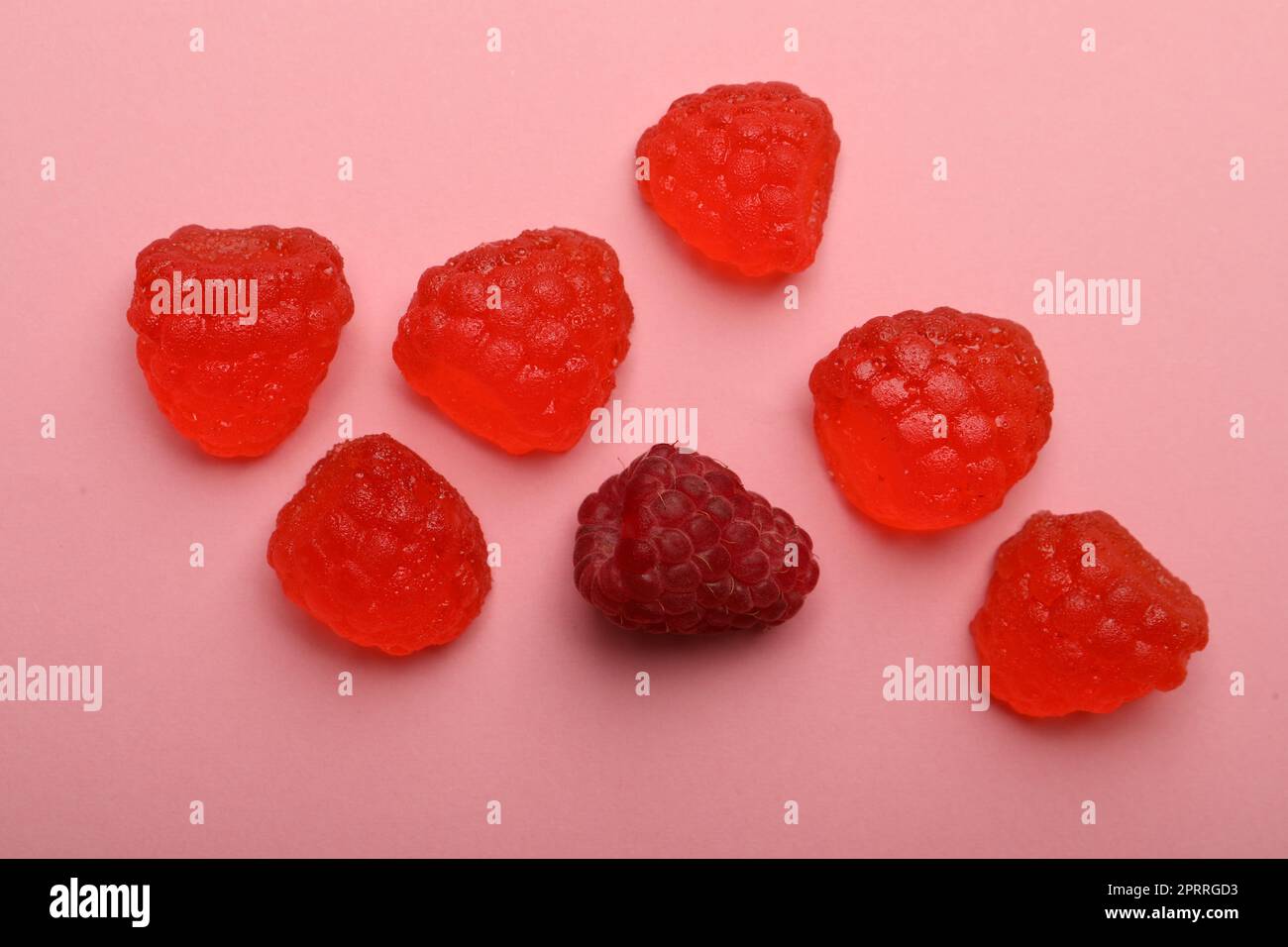 Delicious gummy candies and fresh raspberry on pink background Stock ...