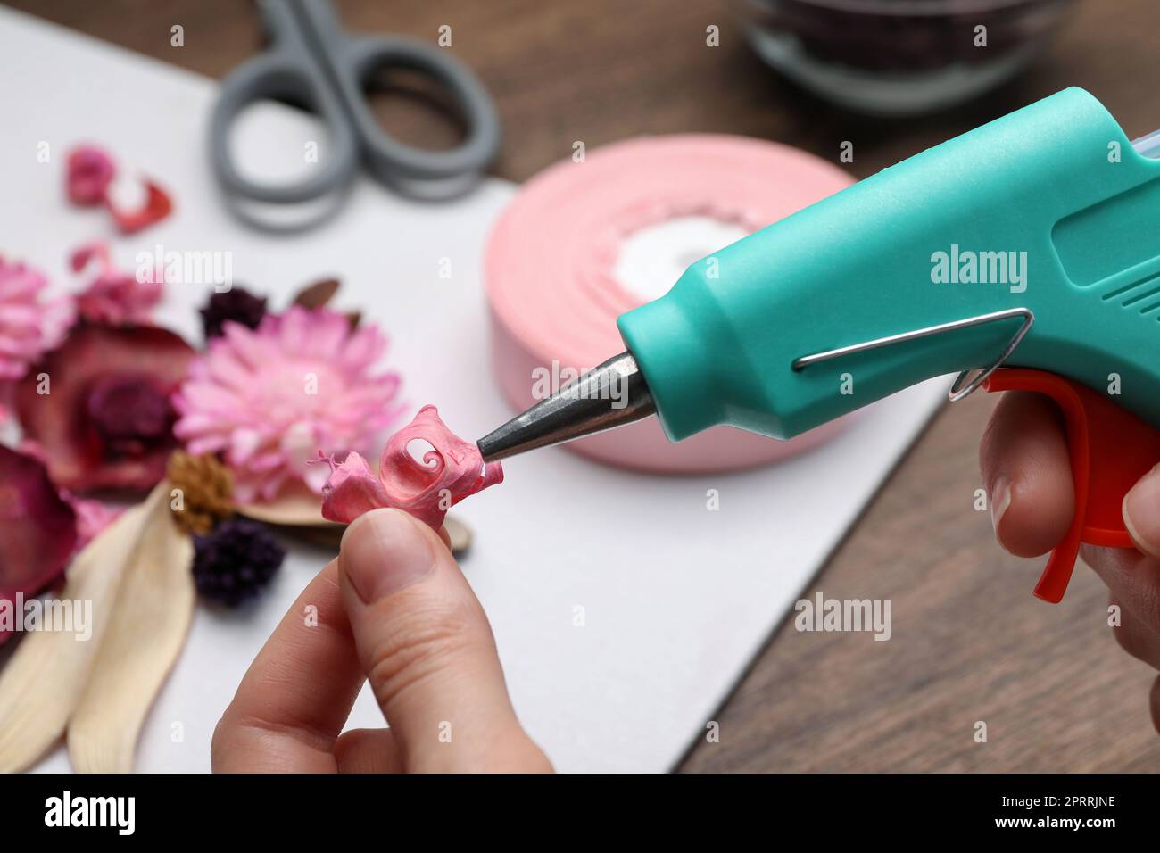 Woman using hot glue gun to make craft at wooden table, closeup Stock ...