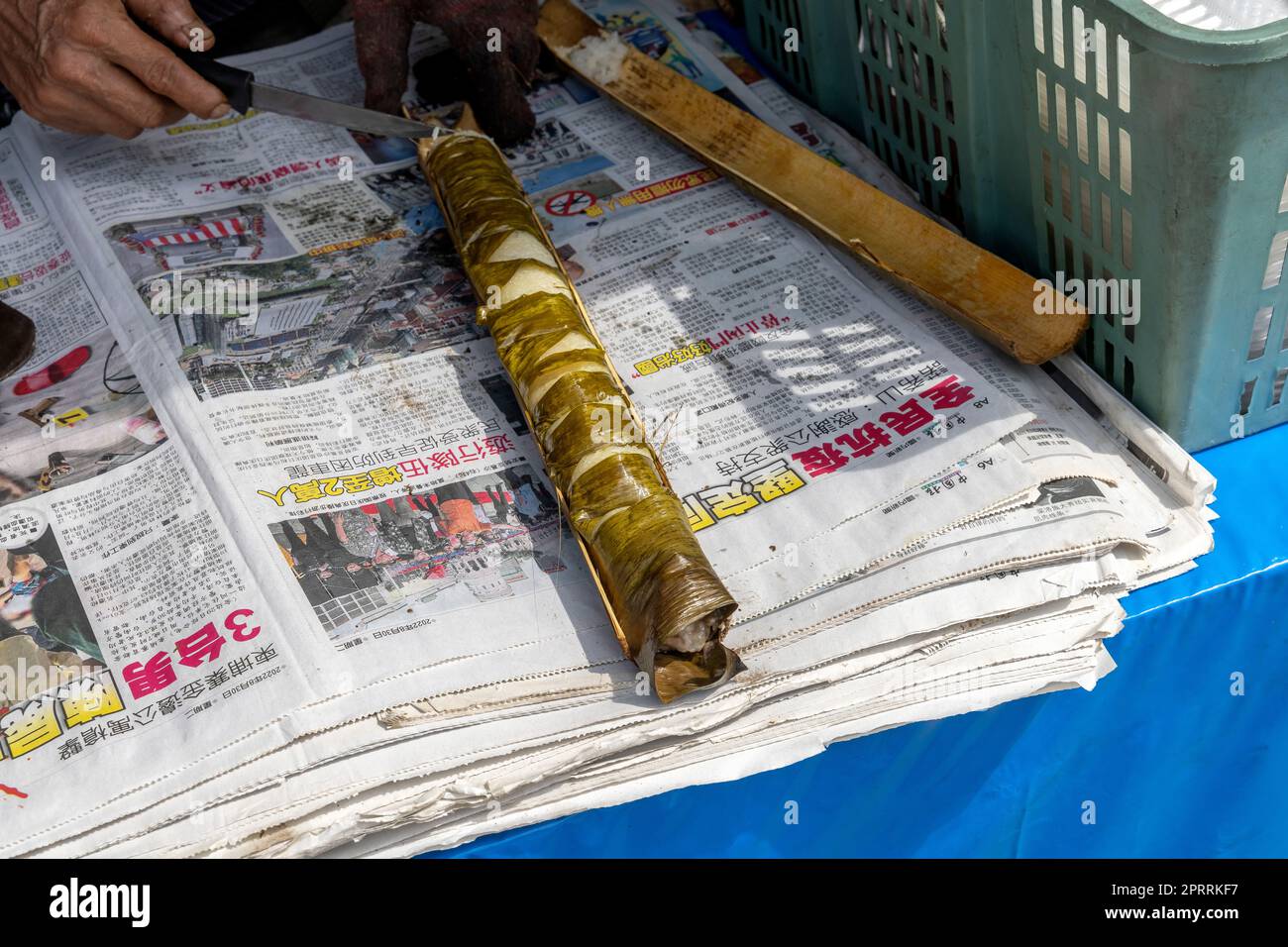 Malaysian man cooking rice in bamboo tube. It is also called Bamboo ...
