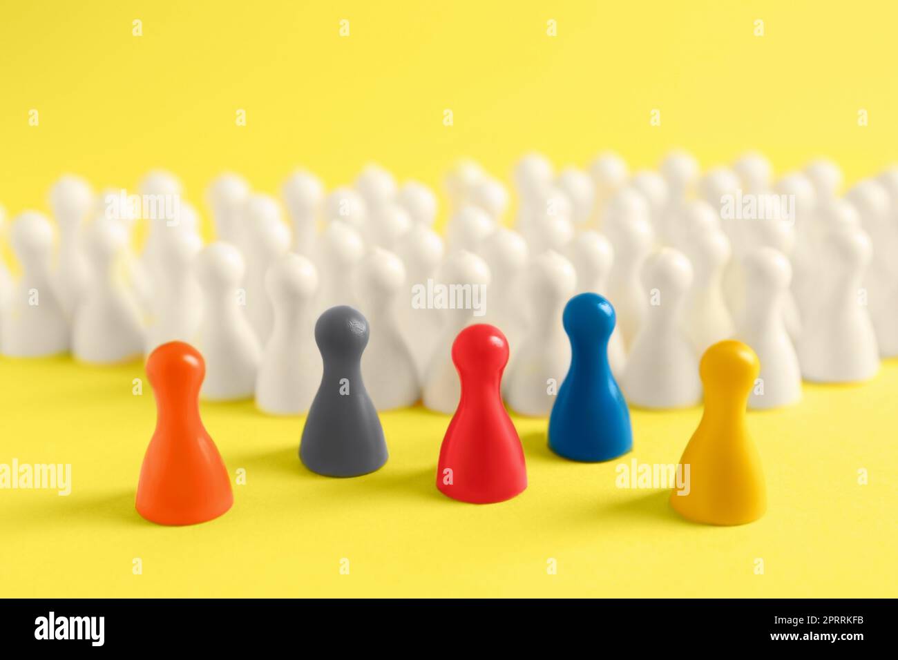 Colorful pawns on yellow background, closeup. Social inclusion concept ...