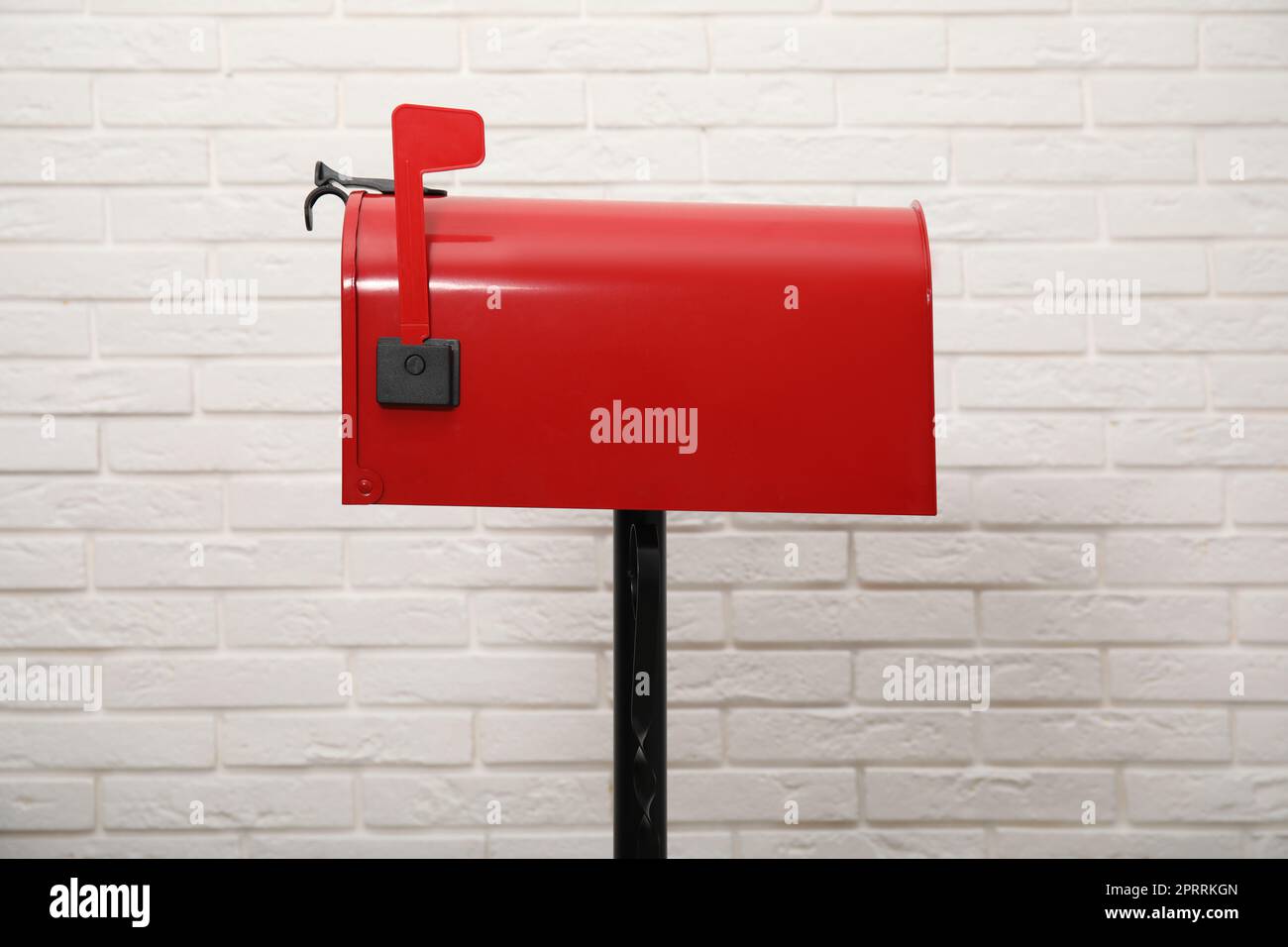 Closed red letter box near white brick wall Stock Photo - Alamy