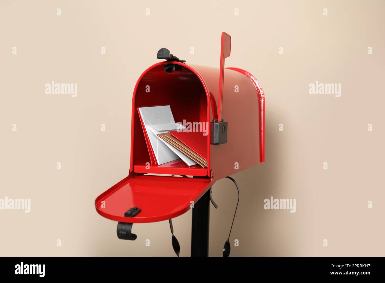 Open red letter box with envelopes against beige background Stock Photo ...