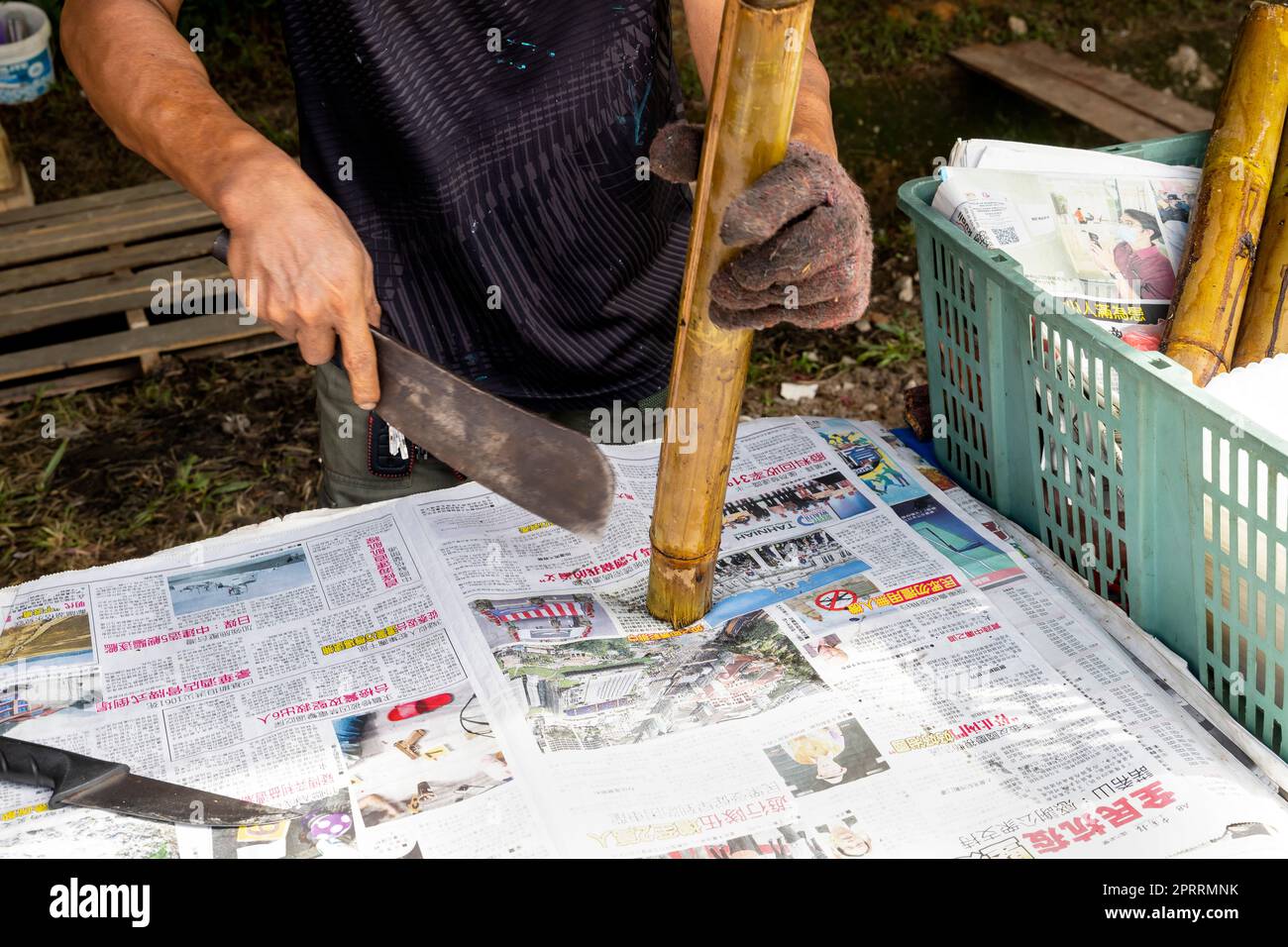 Malaysian man cooking rice in bamboo tube. It is also called Bamboo ...