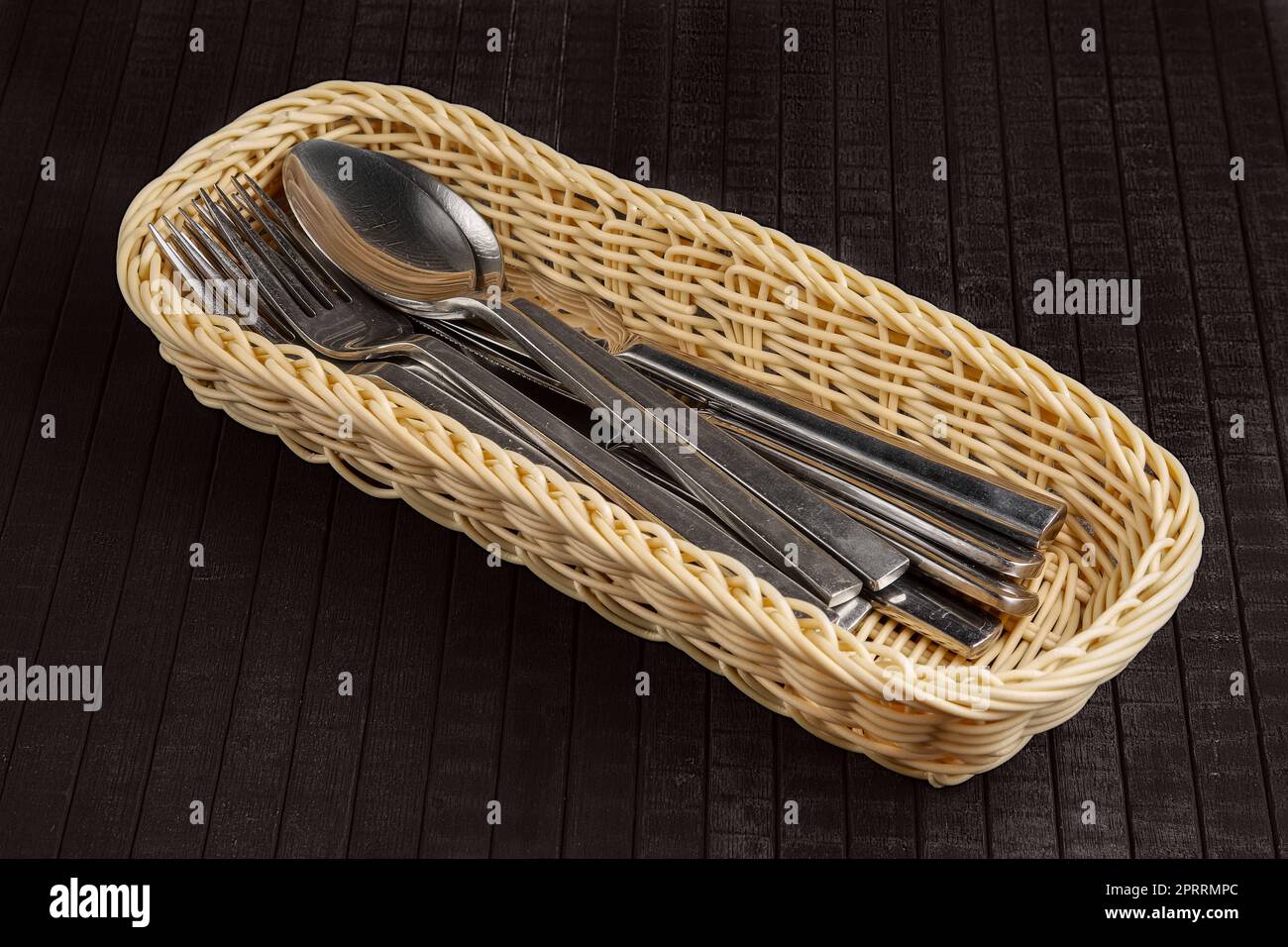 Wicker basket for knives, forks and spoons Stock Photo - Alamy