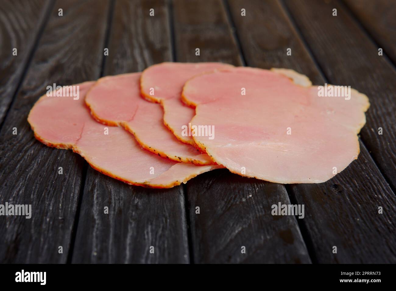 Selective focus photo of slices of fresh ham on wooden table Stock ...