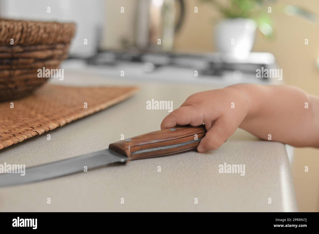 Child holding sharp knife, closeup. Dangers in kitchen Stock Photo - Alamy