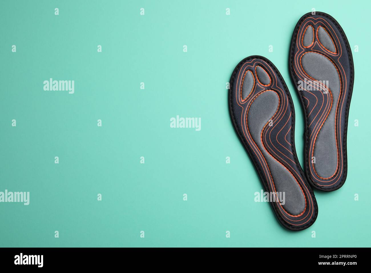 Pair of orthopedic insoles on turquoise background, flat lay. Space for ...