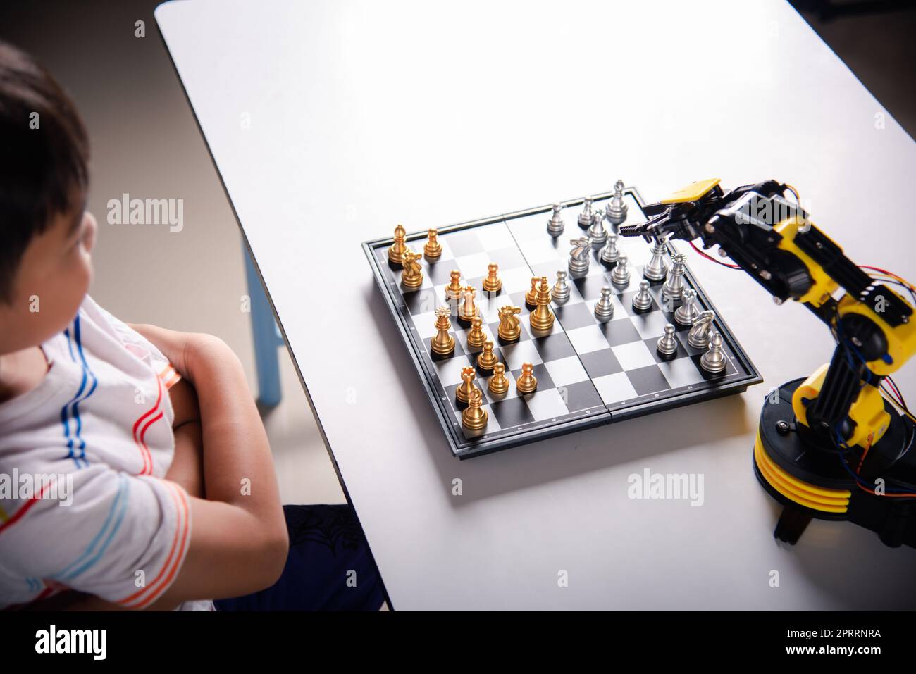 Asian little boy is playing chess with robot machine arm Stock Photo ...