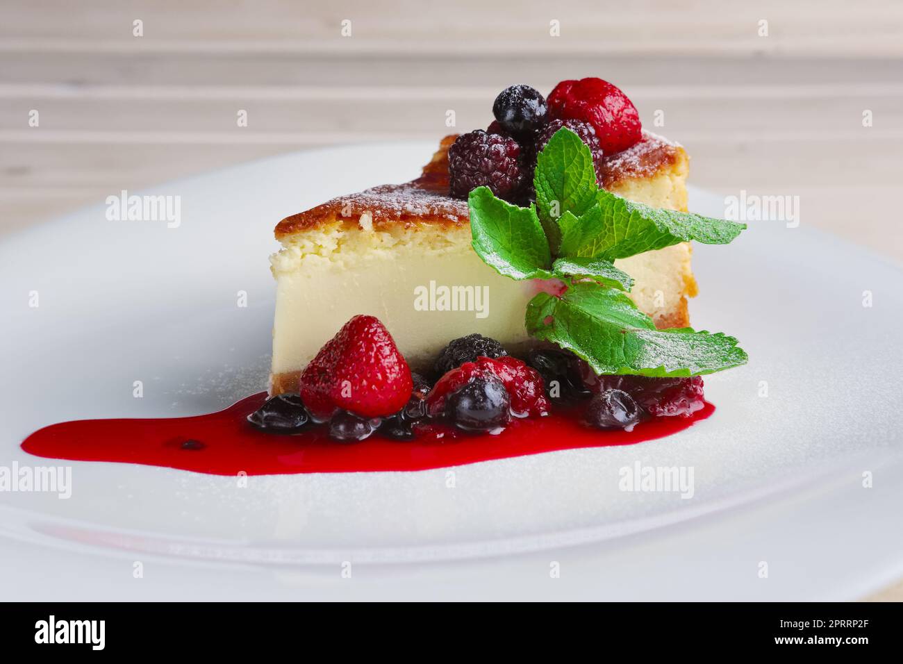 Cheesecake with berries sauce and green mint leaf Stock Photo - Alamy