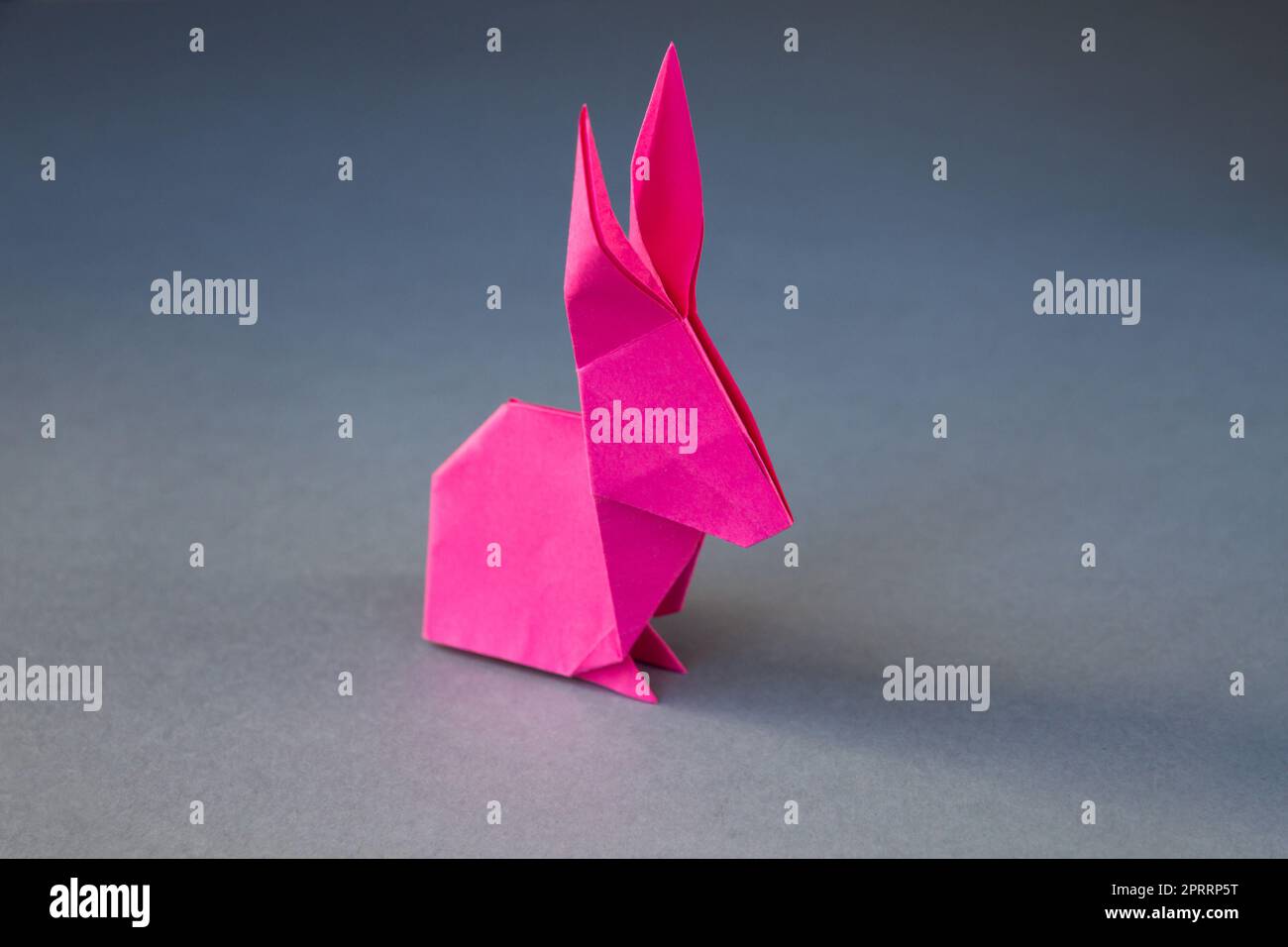 Pink paper rabbit origami isolated on a grey background Stock Photo - Alamy