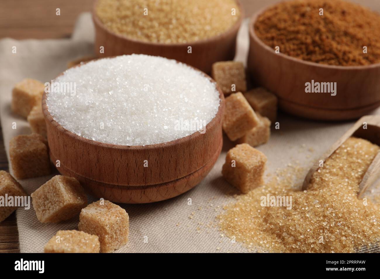 Different types of sugar in granules and cubes on cloth, closeup Stock ...