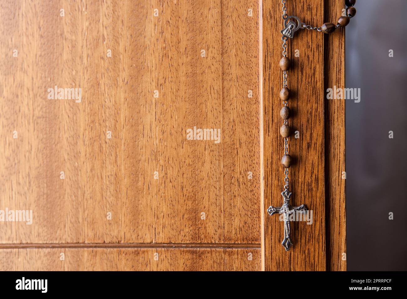 Catholic rosary hanging from wooden door. Selective focus Stock Photo ...
