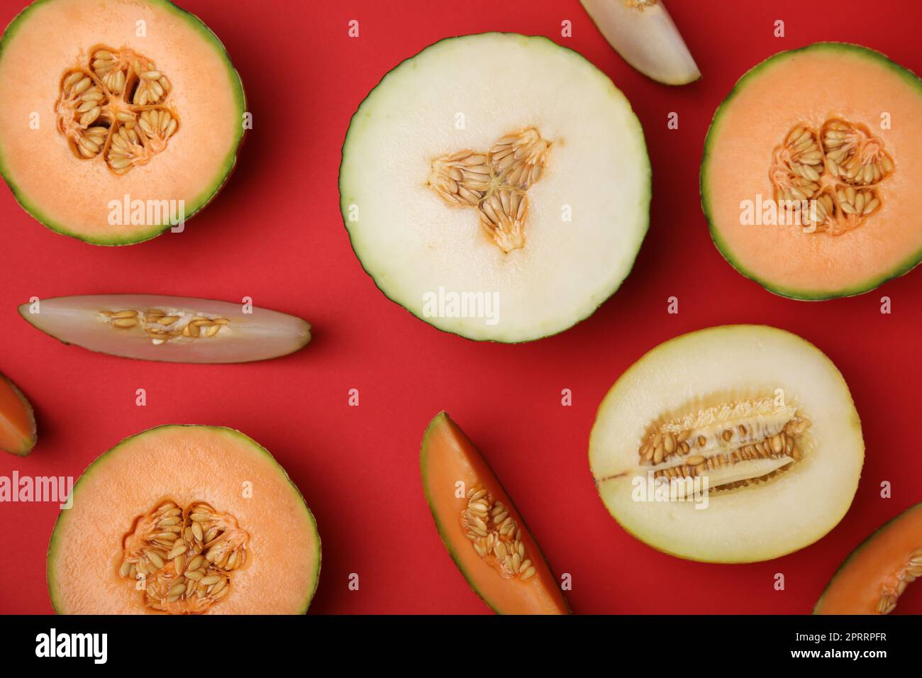 Cut different types of melons on red background, flat lay Stock Photo ...