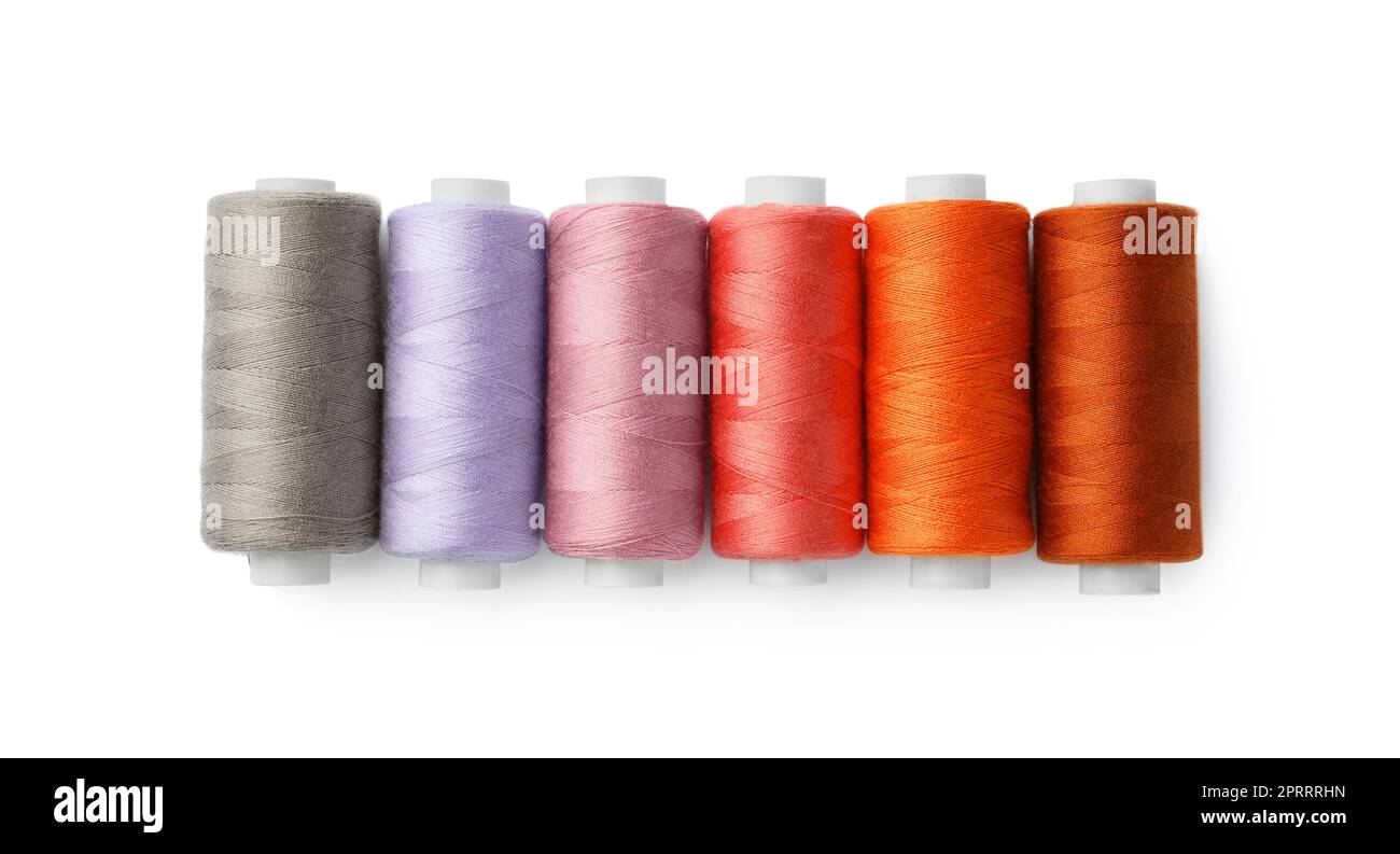 Set of different colorful sewing threads on white background, top view ...