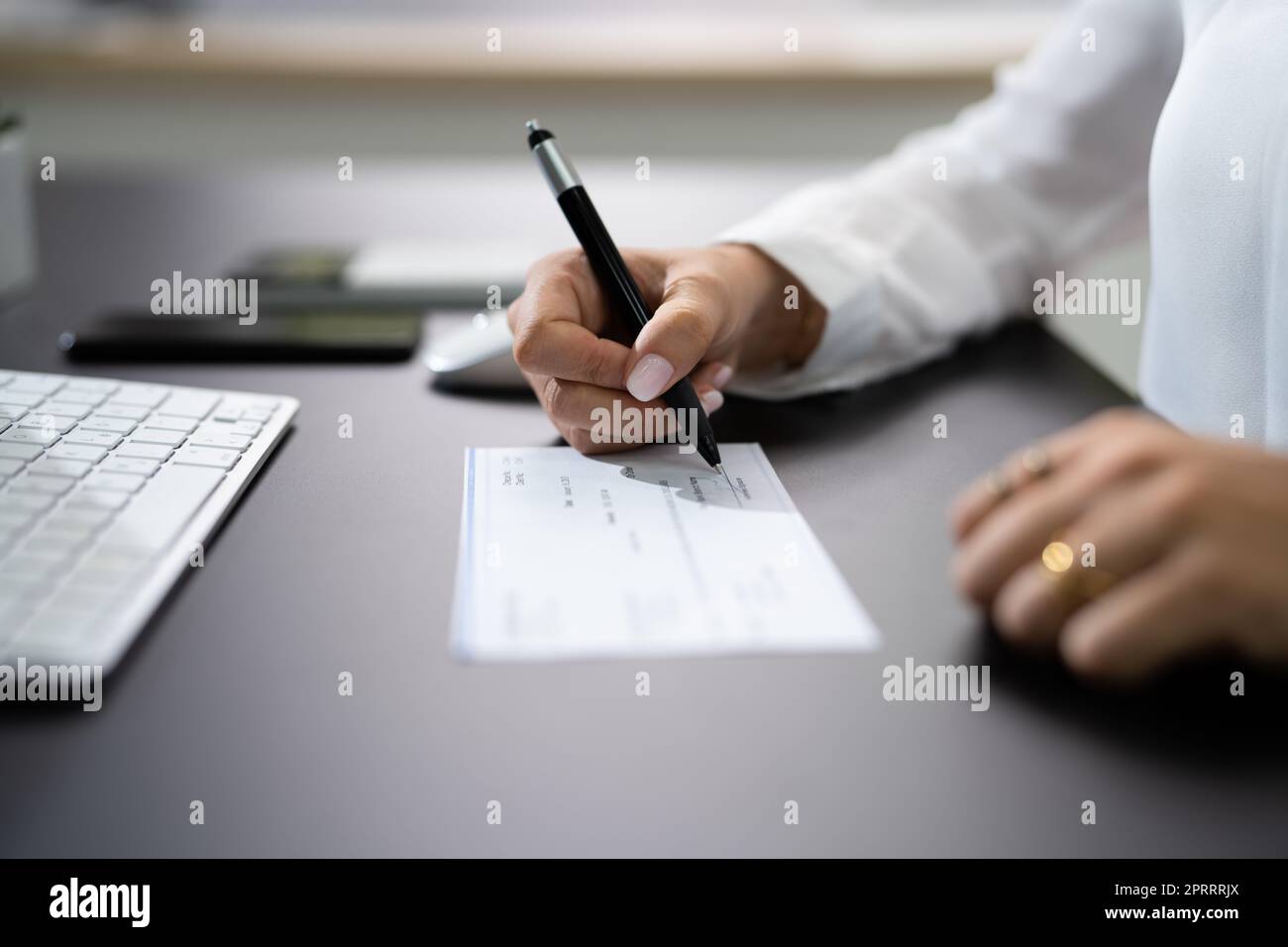 Woman Signing Bank Check Stock Photo - Alamy