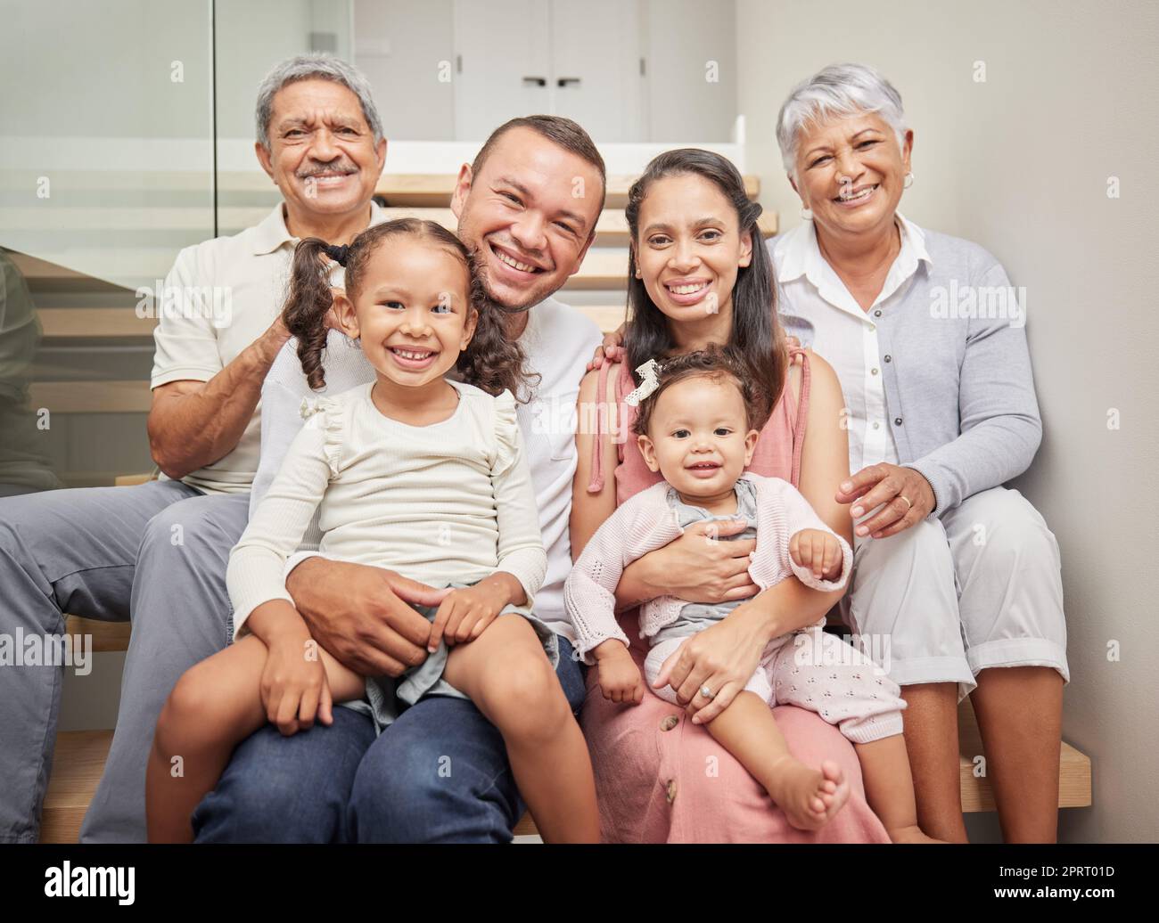 Happy family, portrait and grandparents with baby girls bonding and relaxing together in a ...
