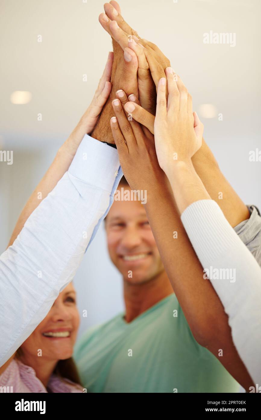 Our symbol of success is working together. a group of coworkers high ...