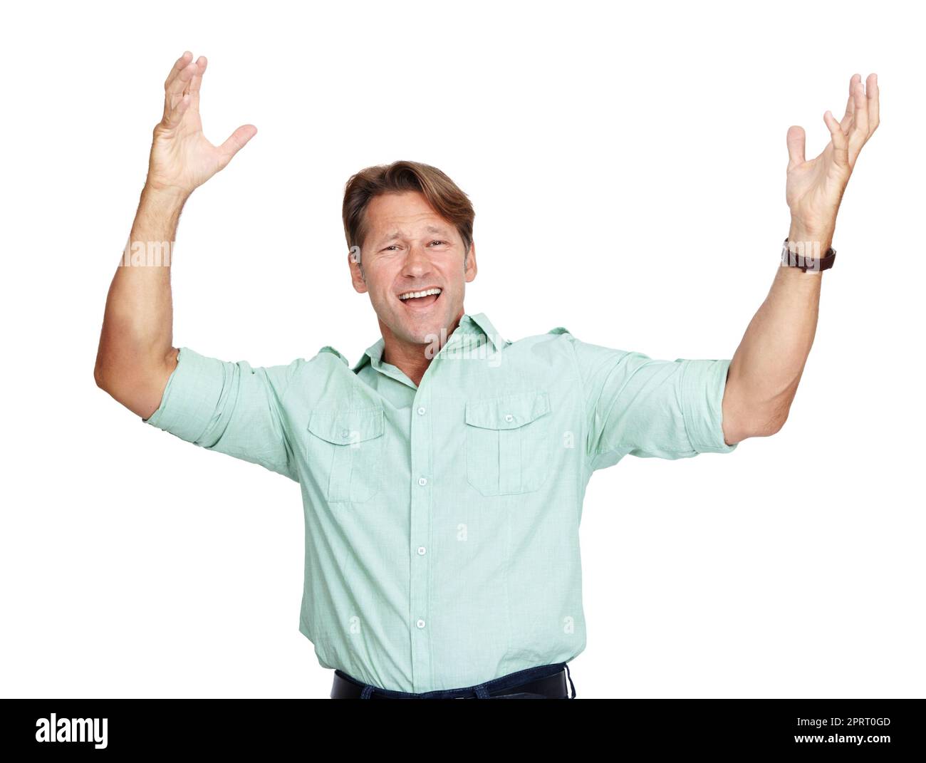 Lets celebrate. An isolated shot of an excited man raising his hands in ...