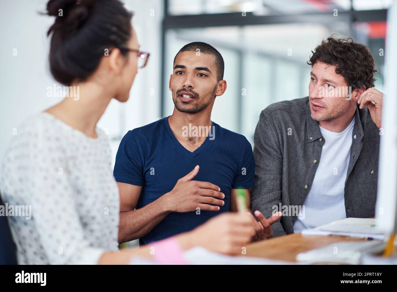 Getting creative with colleagues. a group of designers talking together ...