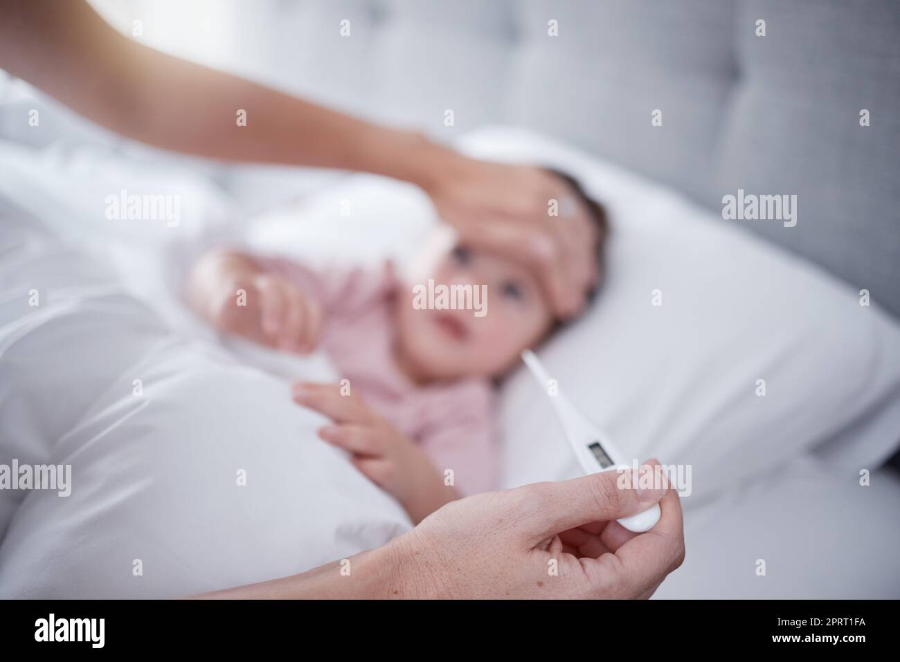 Hands, fever and baby with the hand of a mother taking the temperature ...