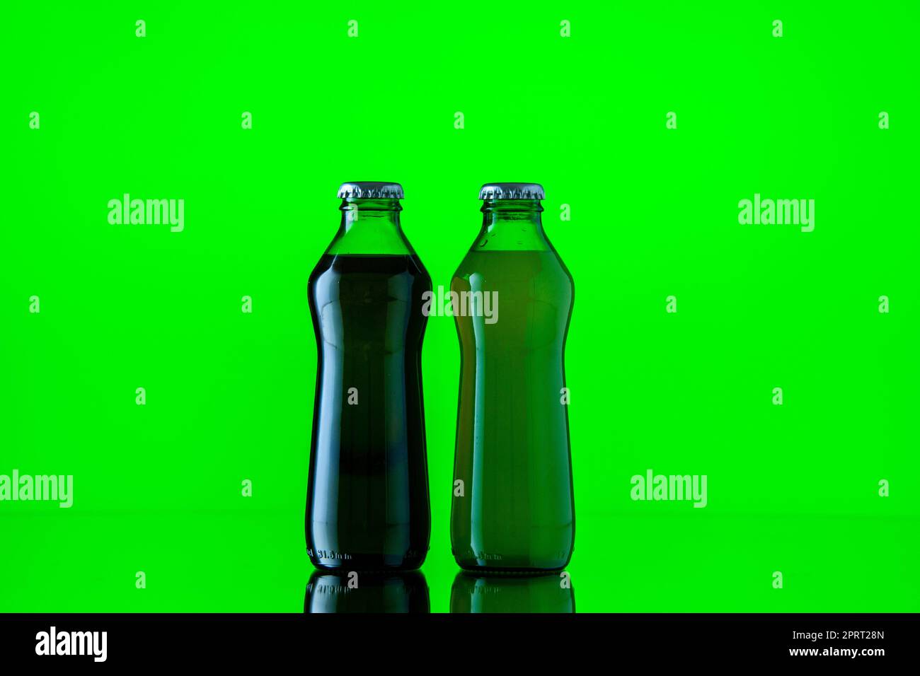 front view soda drink glass bottles on neon green background with free space Stock Photo - Alamy