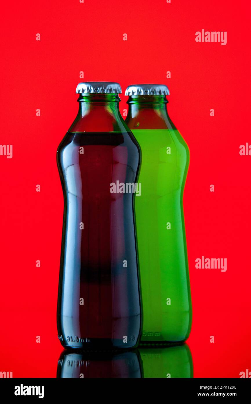 front view soda drink glass bottles on red background Stock Photo - Alamy