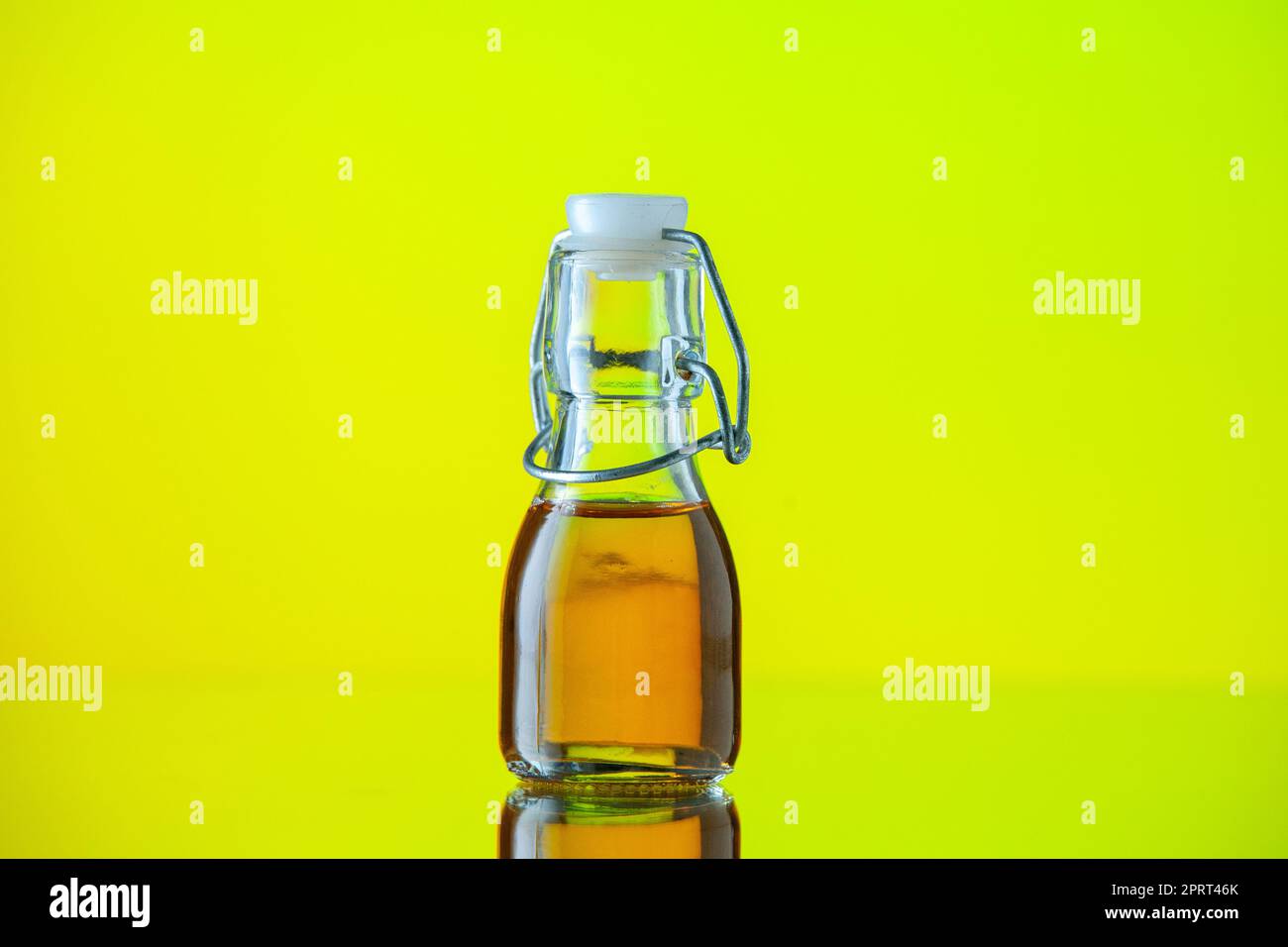 front view bottle with oil on neon yellow background Stock Photo - Alamy