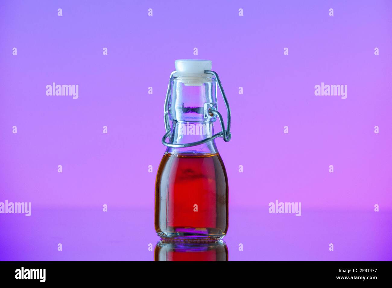 front view bottle with oil on purple background Stock Photo - Alamy