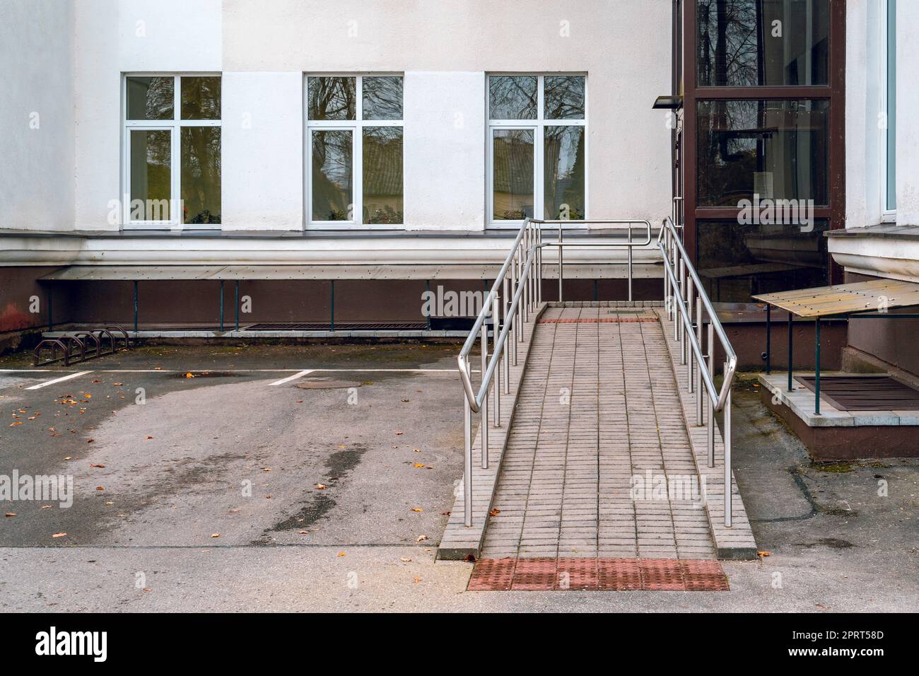 Ramp for wheelchairs and glass elevator on a multistory house facade ...