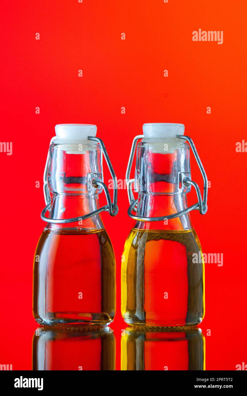 front view two bottles with oil on red background Stock Photo - Alamy