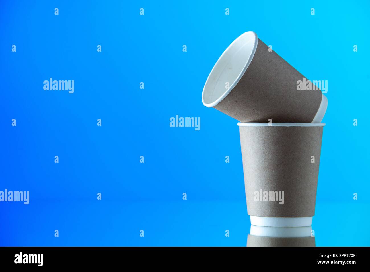 front view two paper water cups stacked on top of each other on blue ...