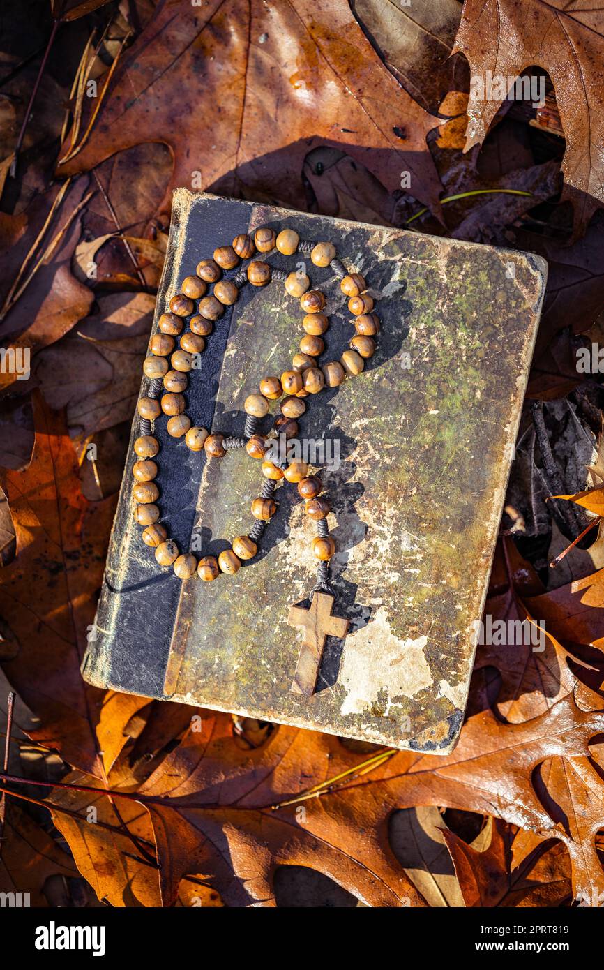 Wooden rosary beads and holy bible book lying on the autumn leaves. Top ...