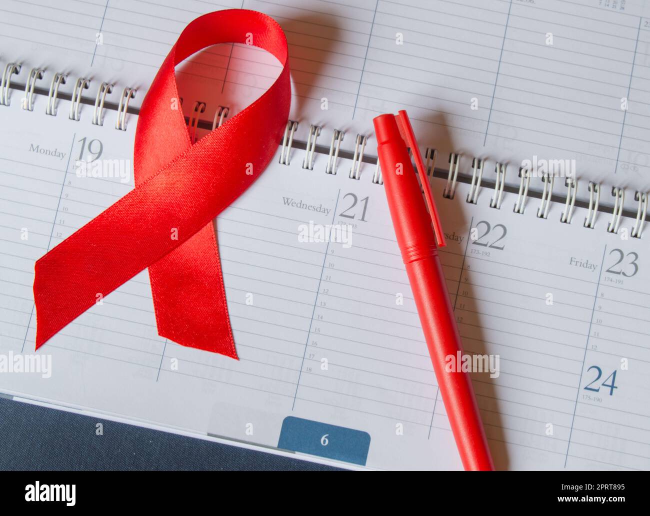 Red ribbon on the calendar to raise awareness against AIDS copy space ...