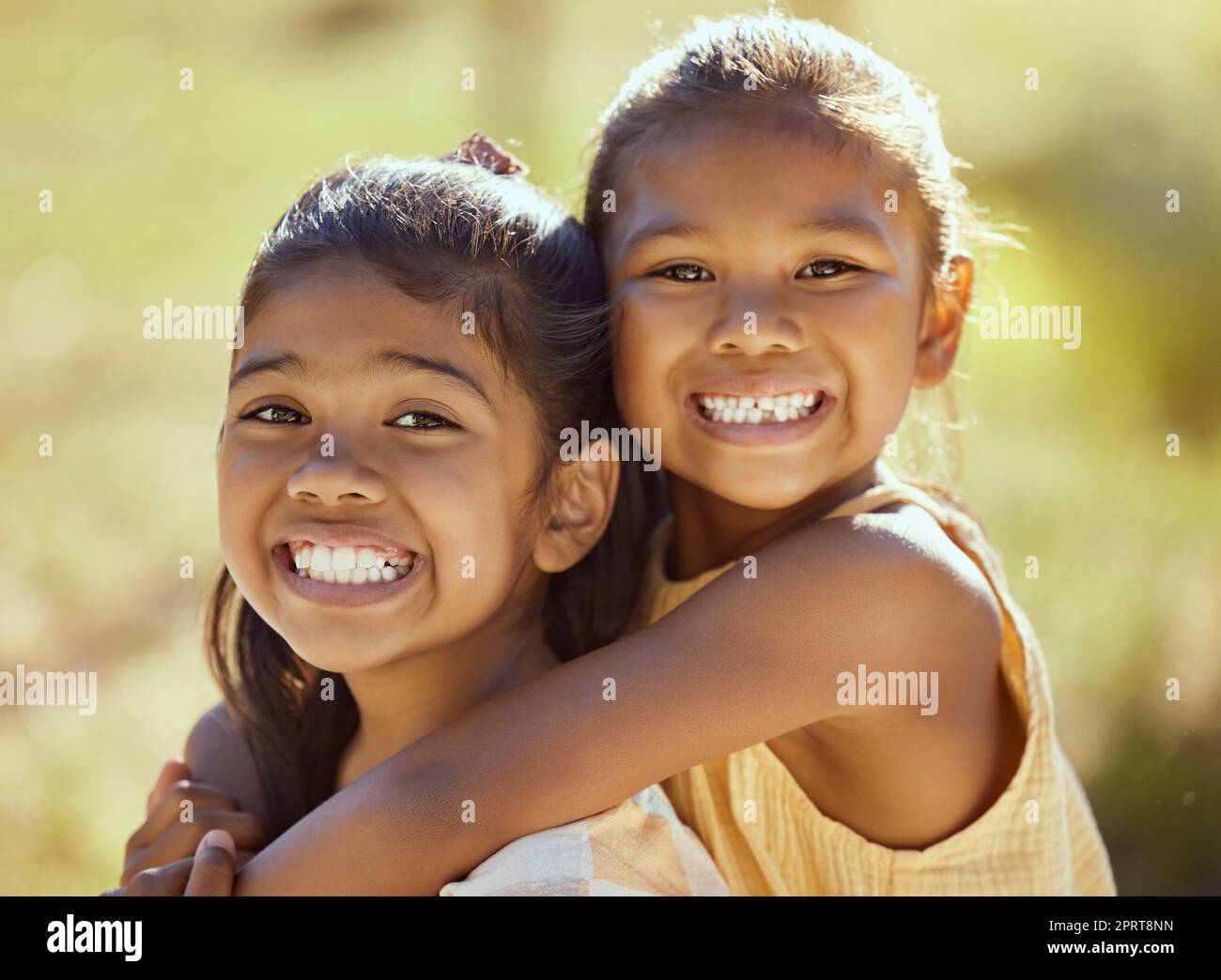 Love, kids and girls hug in nature outdoors while siblings happy ...