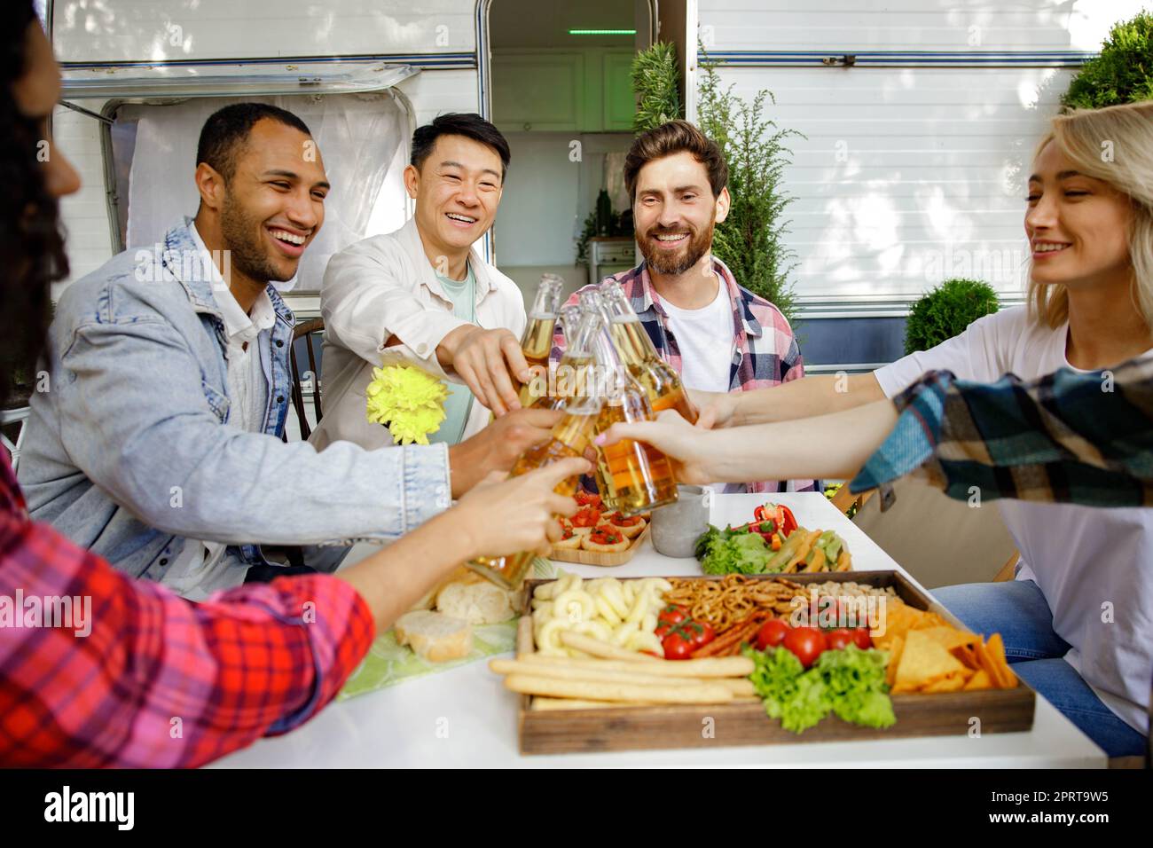 A cheerful multinational company is having fun on a picnic. Multisex ...