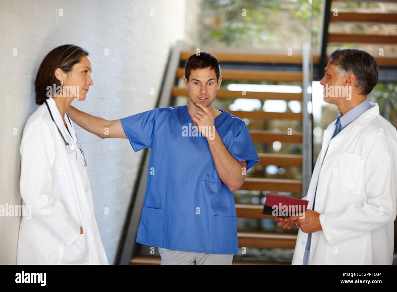 Its a tough call...A cropped shot of three doctors standing and having ...