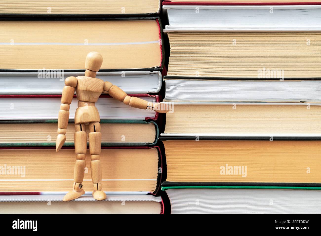 Wooden mannequin standing on the stack of books Stock Photo - Alamy