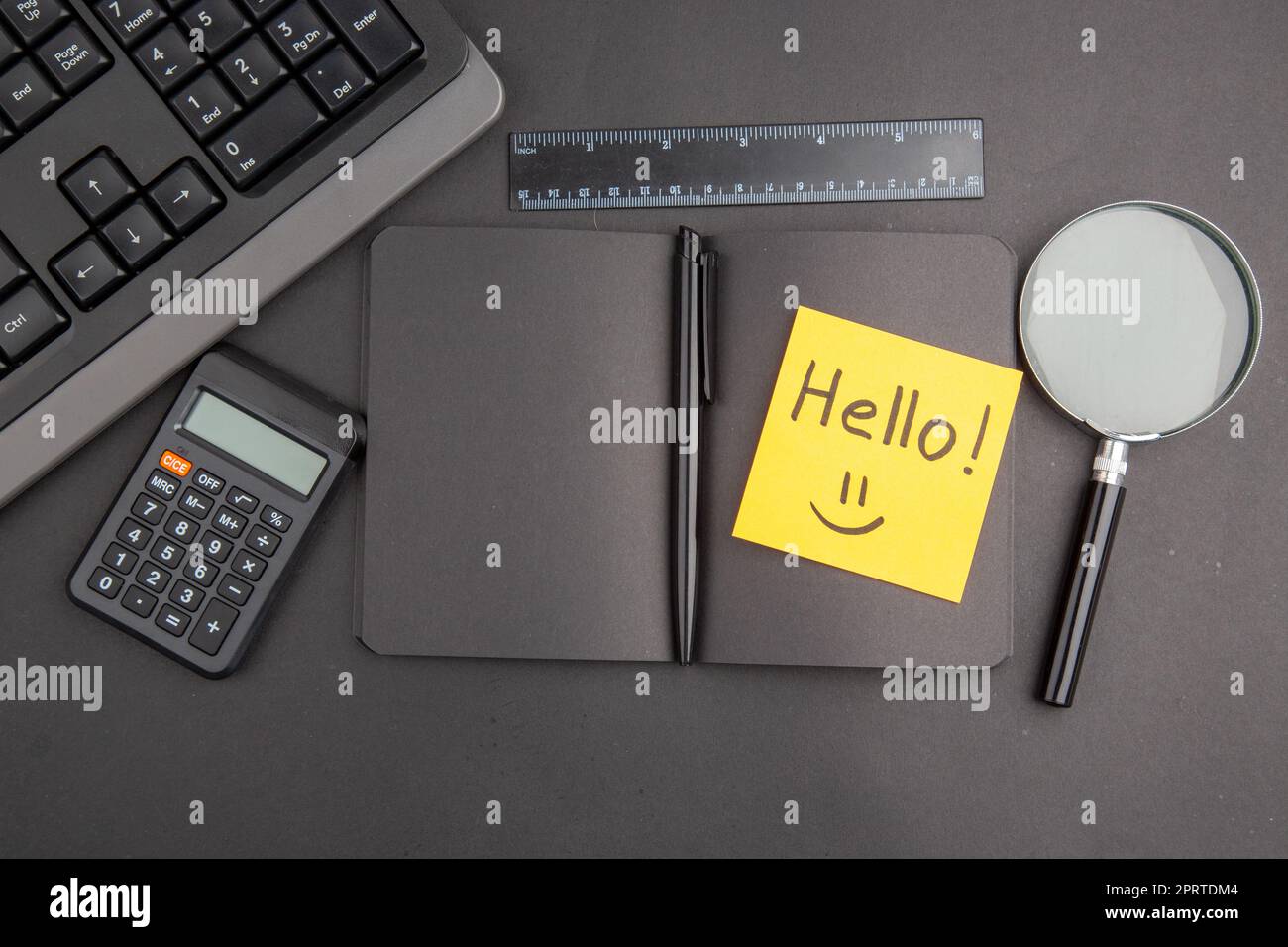 top view black notebook pen keyboard hello written on note paper lupa ...