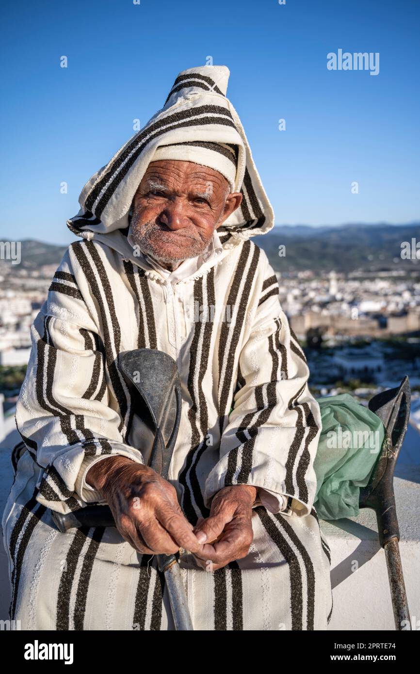 Portrait of an elderly Moroccan man on crutches and dressed in the ...