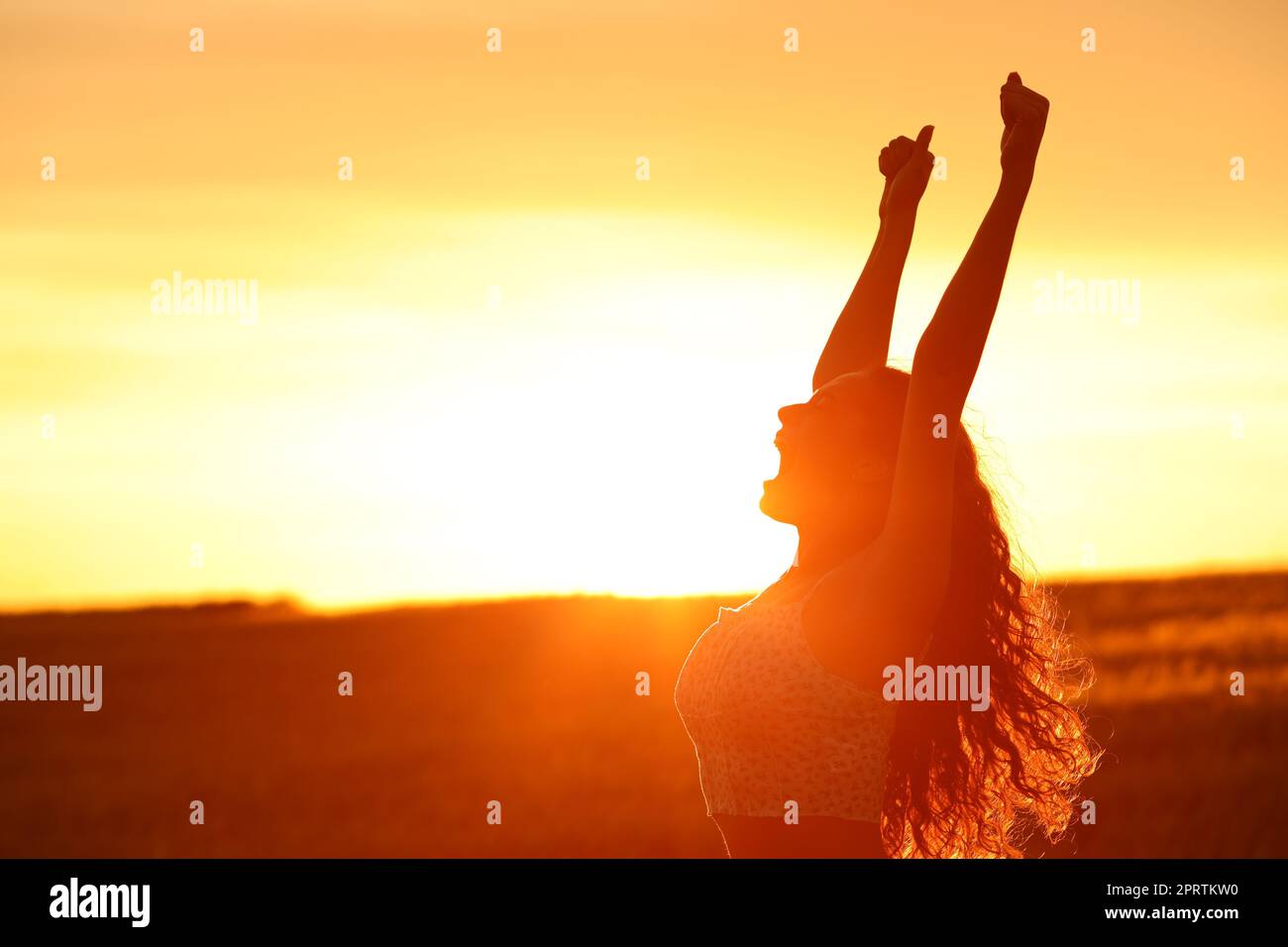 Excited woman raising arms at sunset celebrating Stock Photo - Alamy