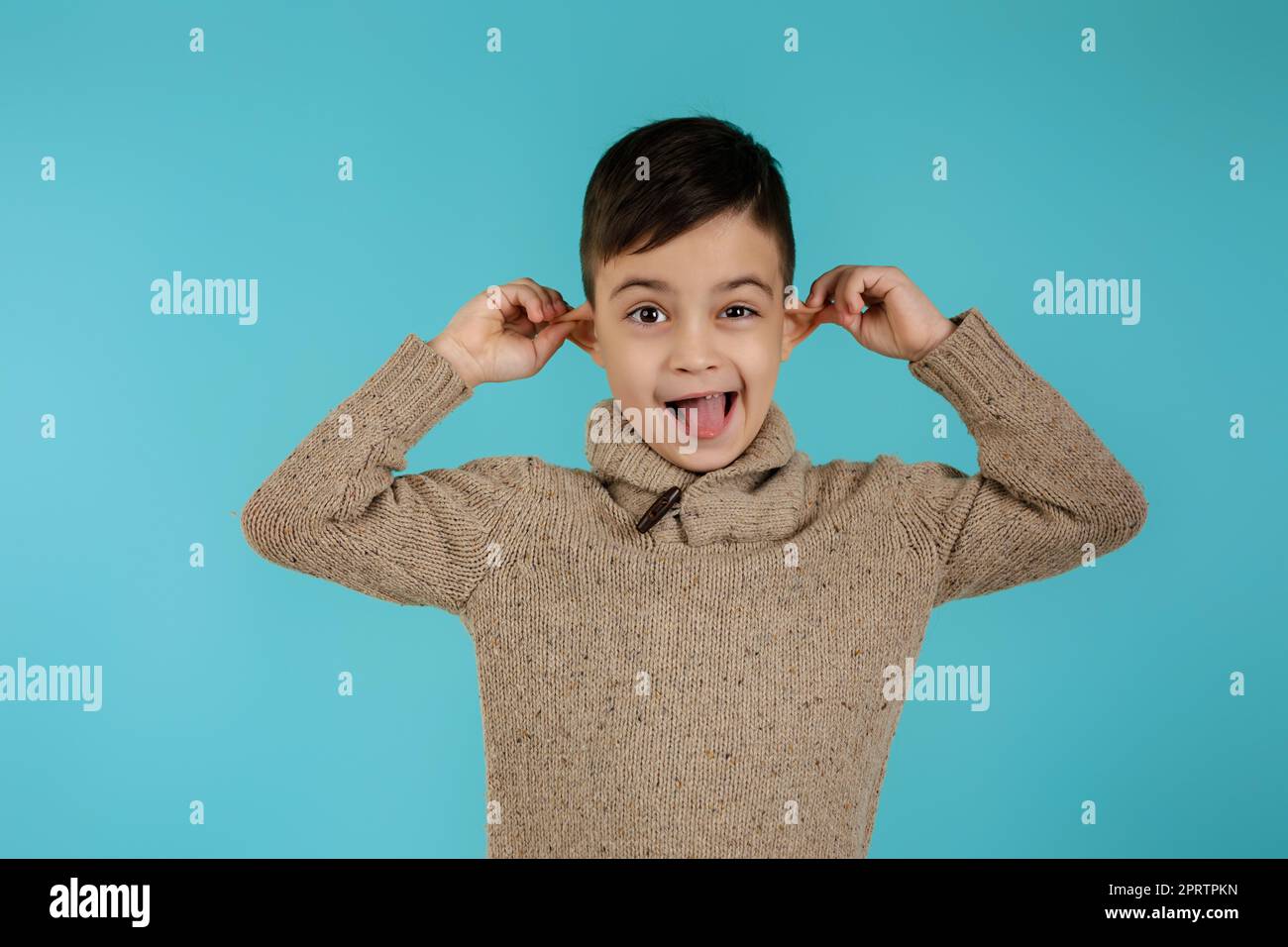 happy funny little child boy showing her tongue on blue background ...