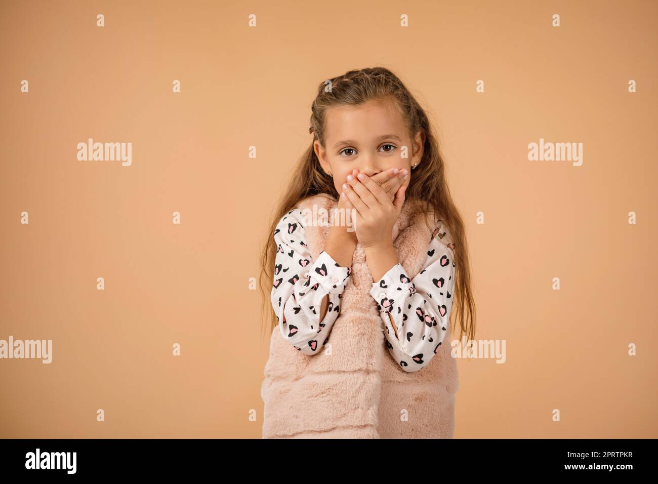 beautiful little girl asking to be quiet. child closes her mouth with ...