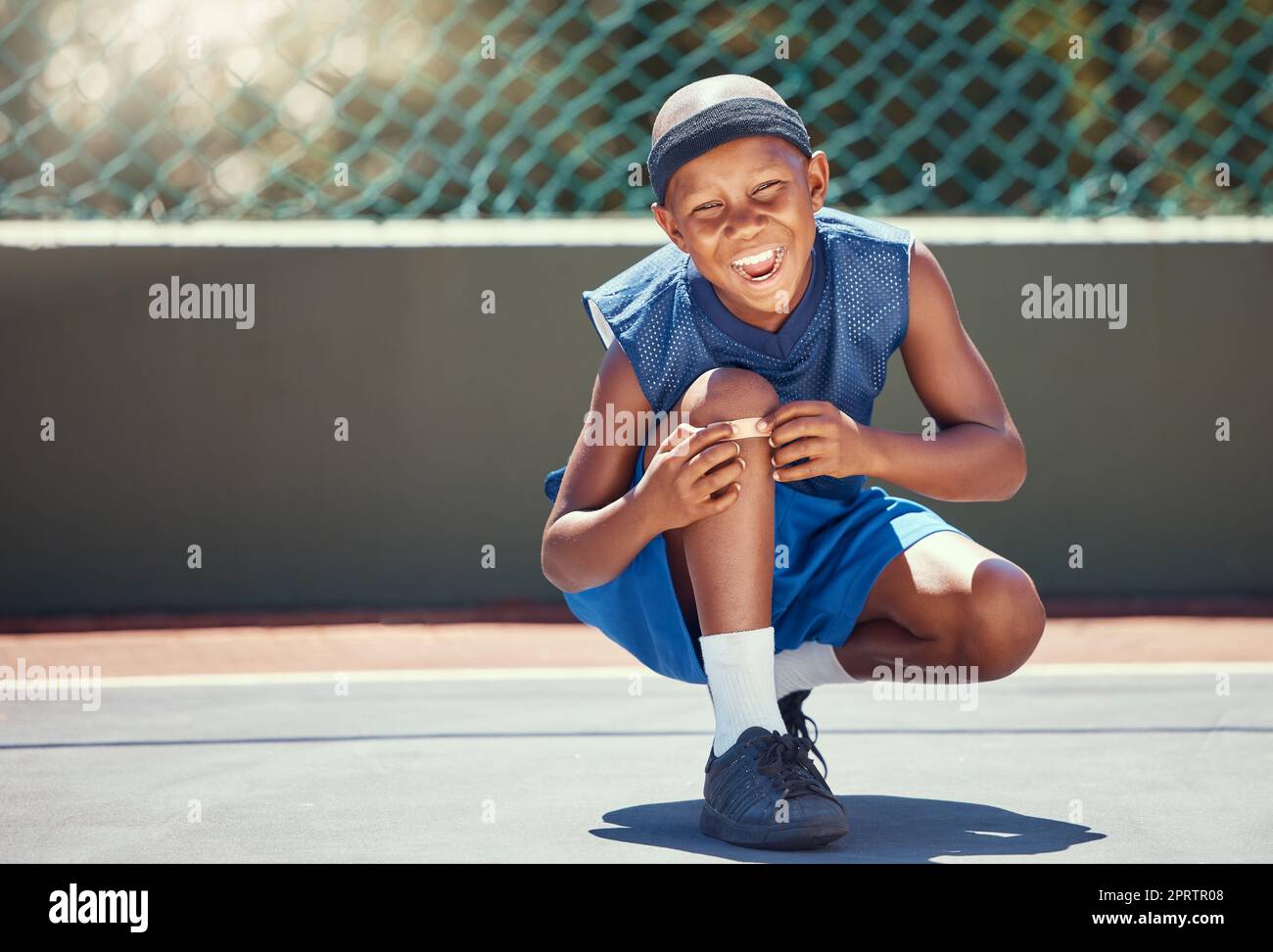 Boy touching injured knee hi-res stock photography and images - Alamy