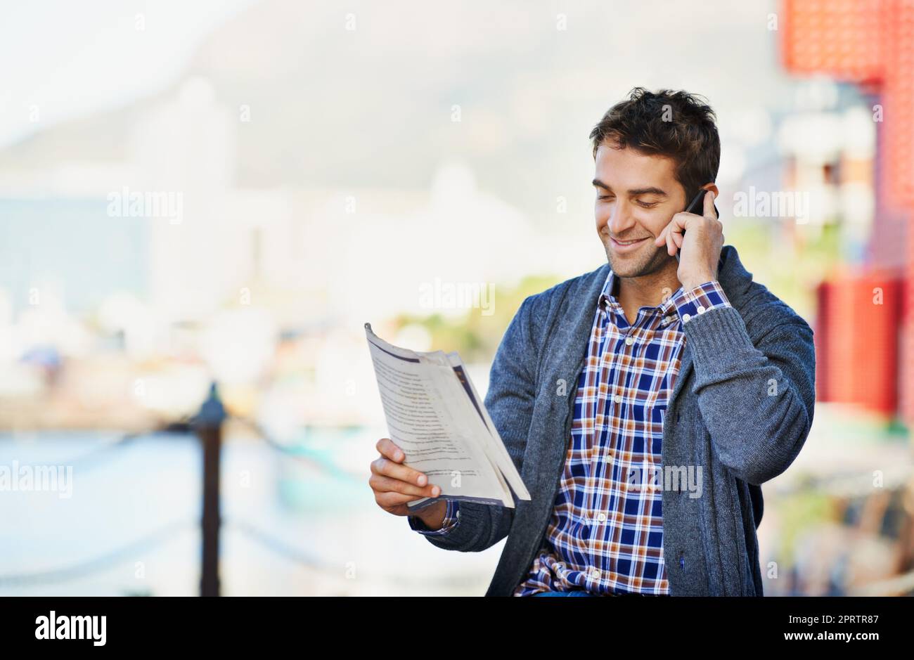 Did you check the news...a handsome man holding the newspaper and using ...