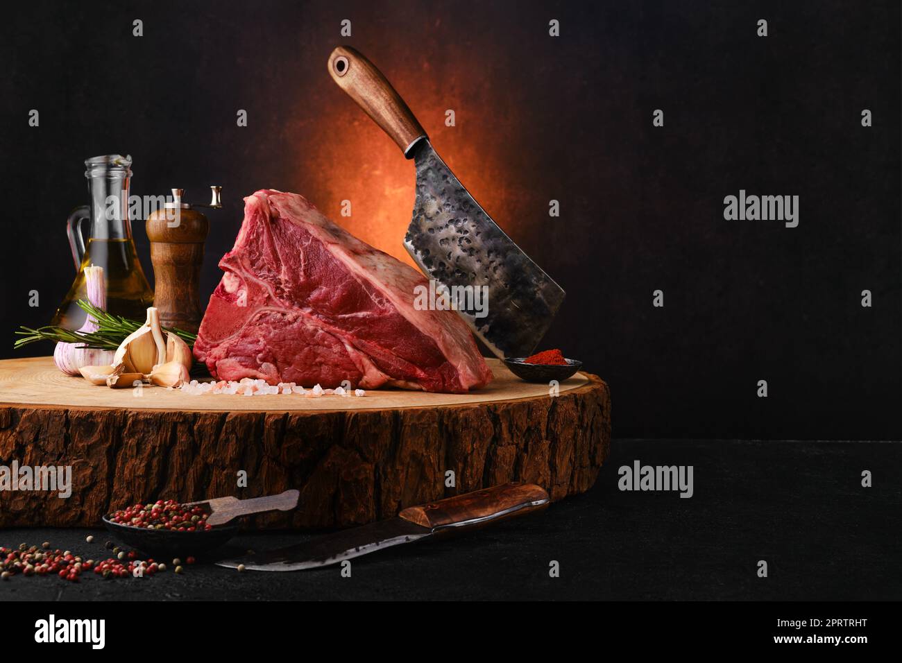 Raw fresh porterhouse steak with ingredients for cooking on wooden log ...