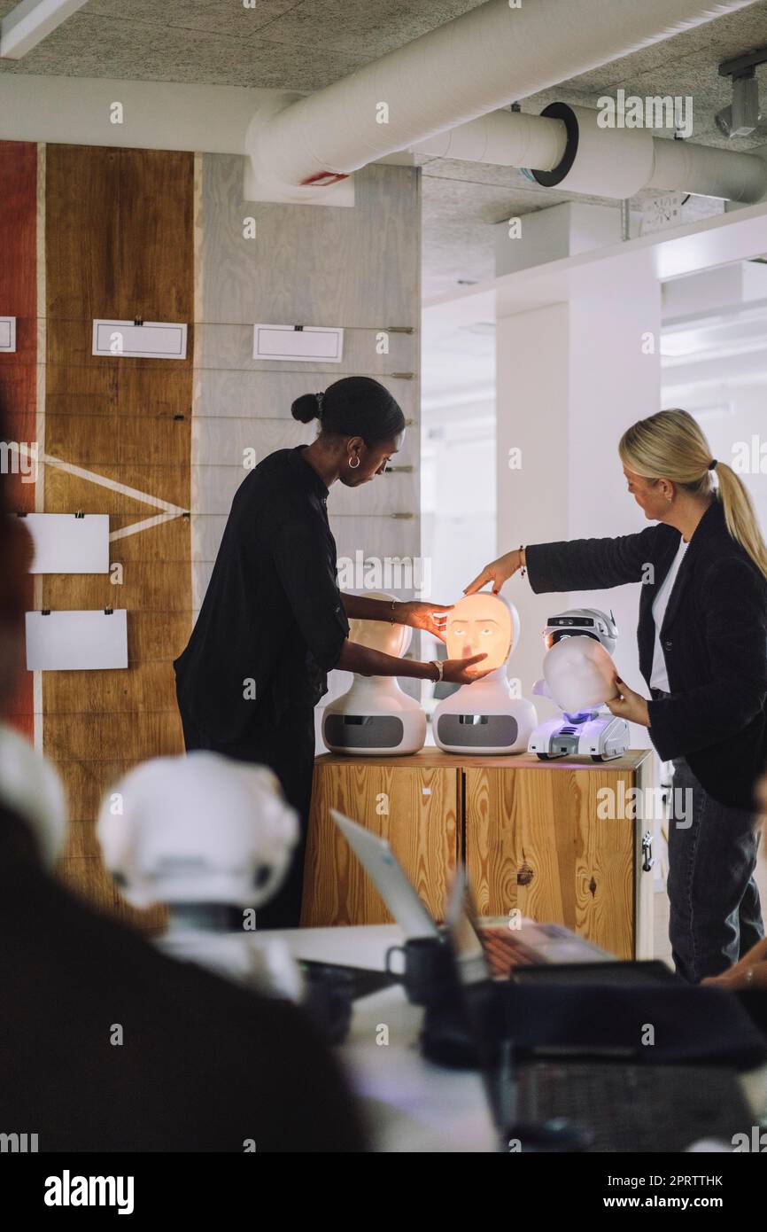 Female professor discussing with student over social robot in ...