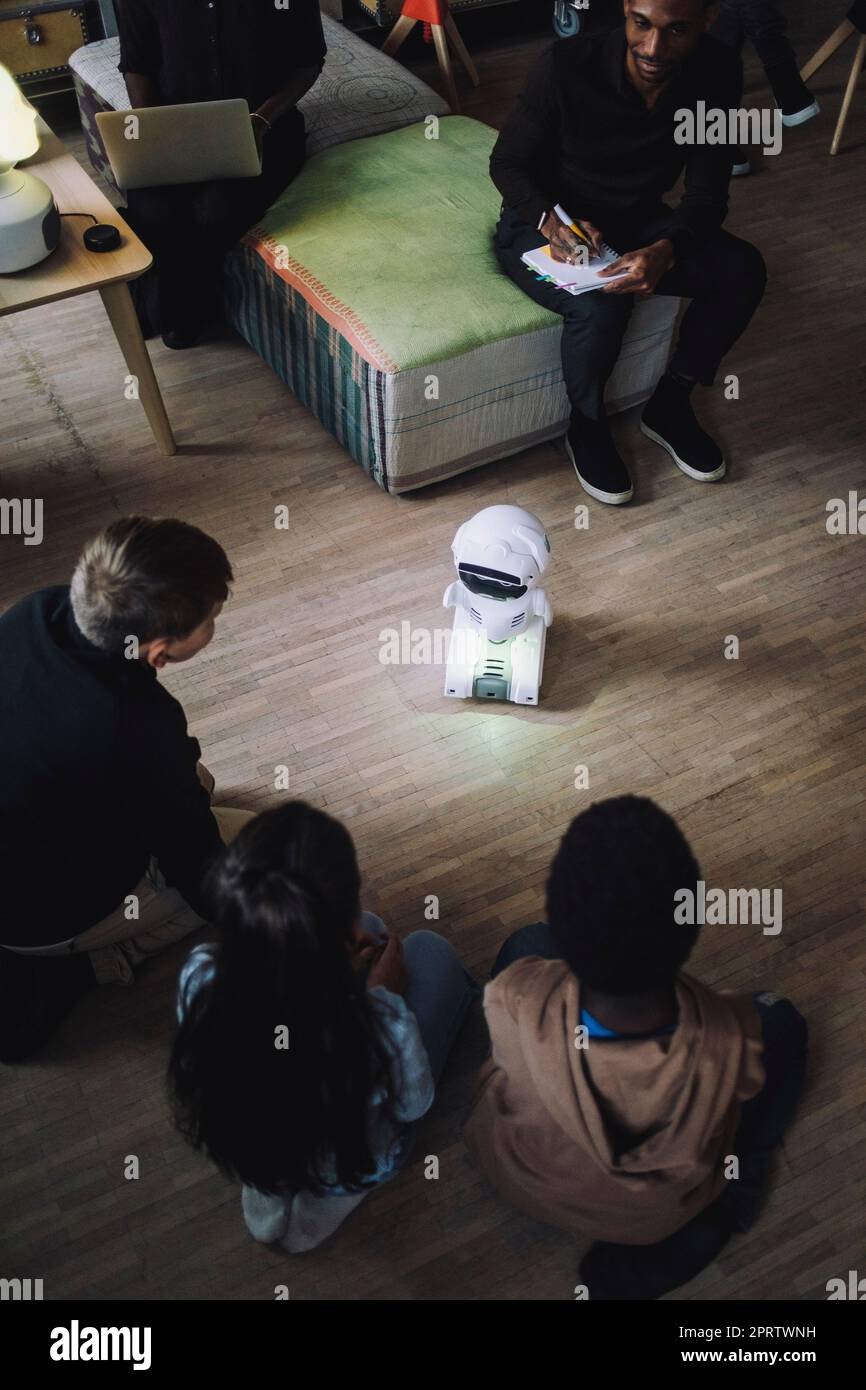High angle view of multiracial children sitting in front of social ...