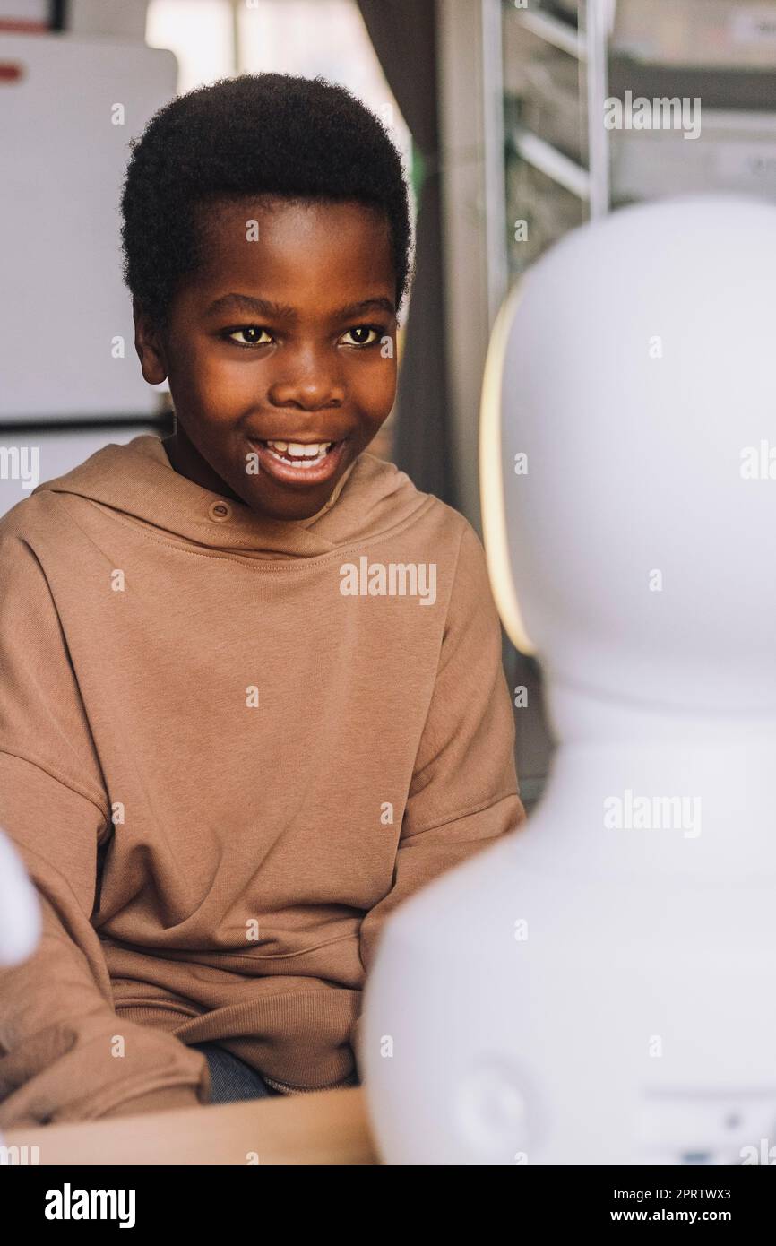 Curious boy looking at AI social robot in innovation lab Stock Photo ...