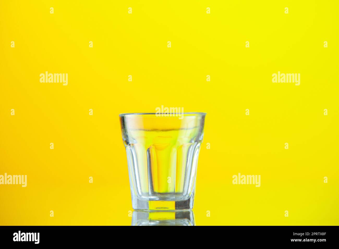 front view water glass on neon yellow background Stock Photo - Alamy
