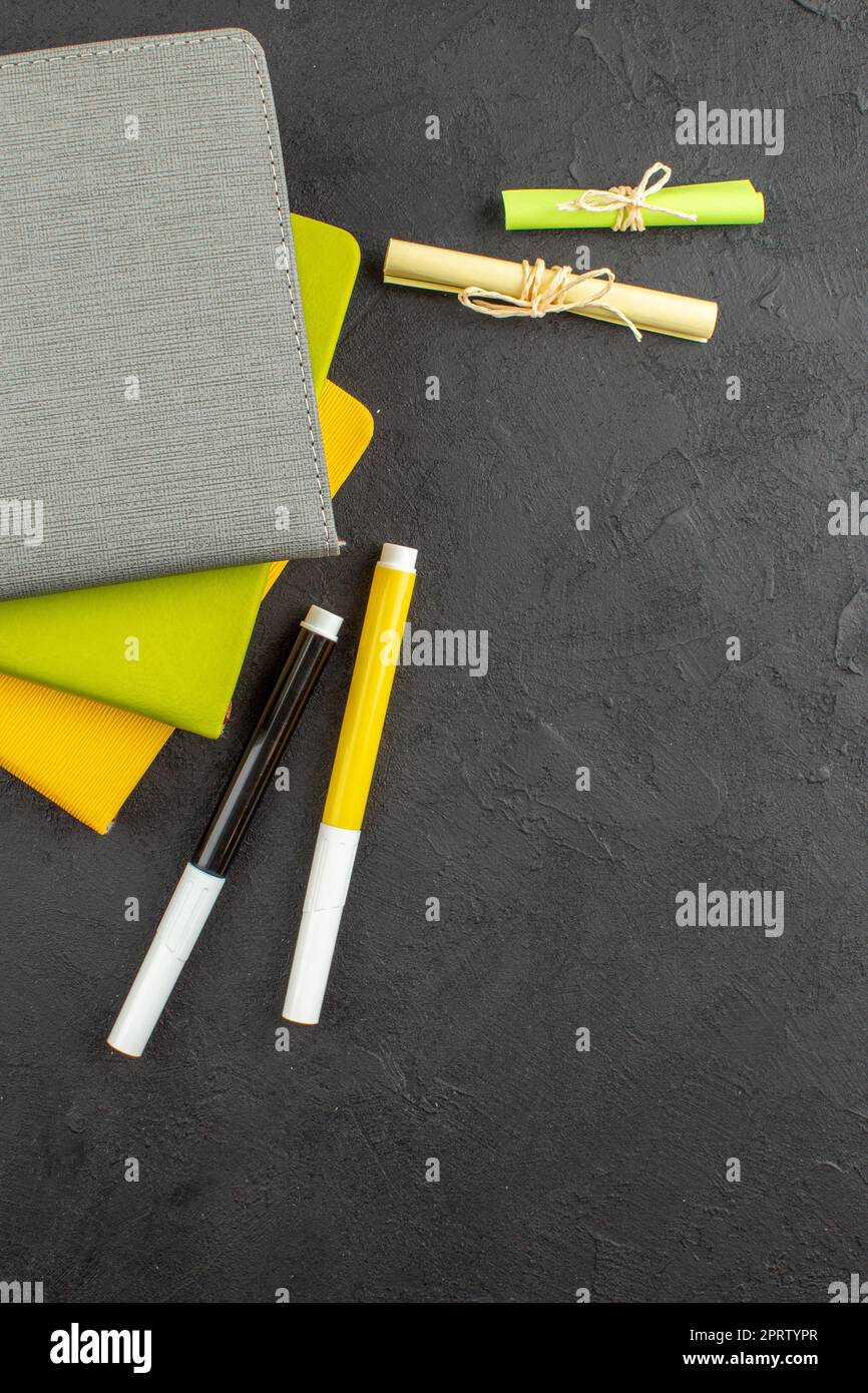 top view colorful notepads yellow and black pencils on black background ...